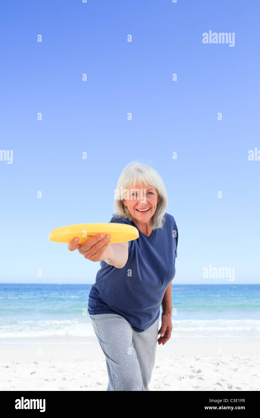 Elderly woman playing freesby Stock Photo - Alamy