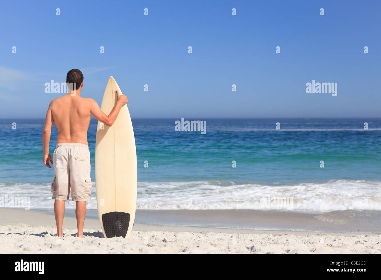 Man wirth his surfboard on the beach Stock Photo - Alamy
