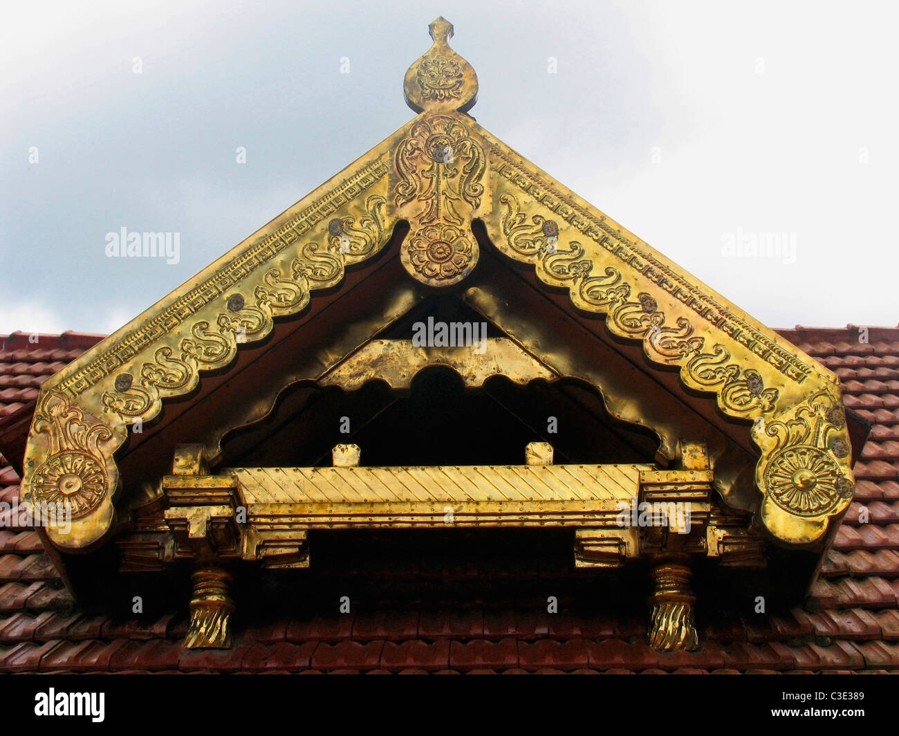 The golden, decorated arch of the entrance of Durga temple at Nenmara ...