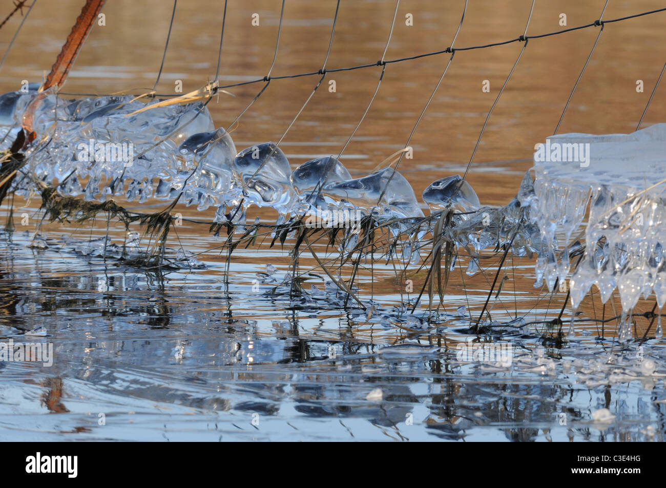 Icicles, old wire mesh fence, H2O in solid form Stock Photo - Alamy