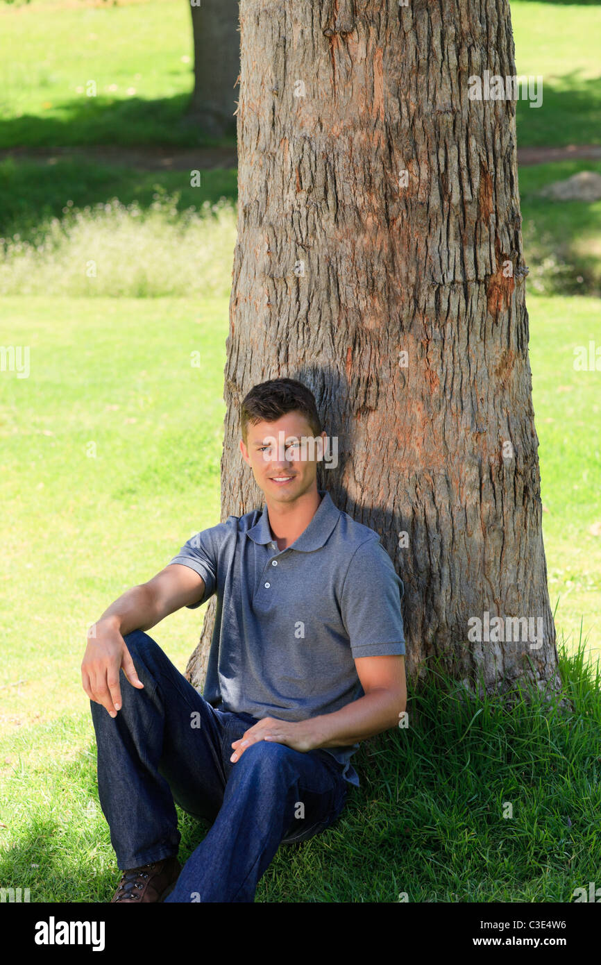 Man sitting beside tree hi-res stock photography and images - Alamy