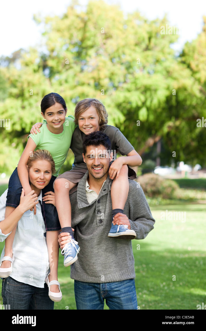 Parents giving children a piggyback during the summer Stock Photo - Alamy