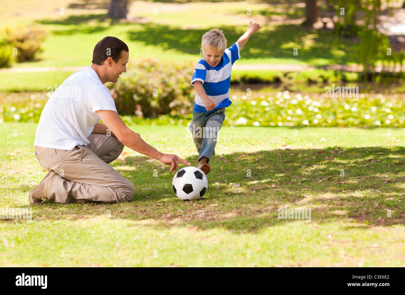 Father playing football with his son in a park Stock Photo - Alamy