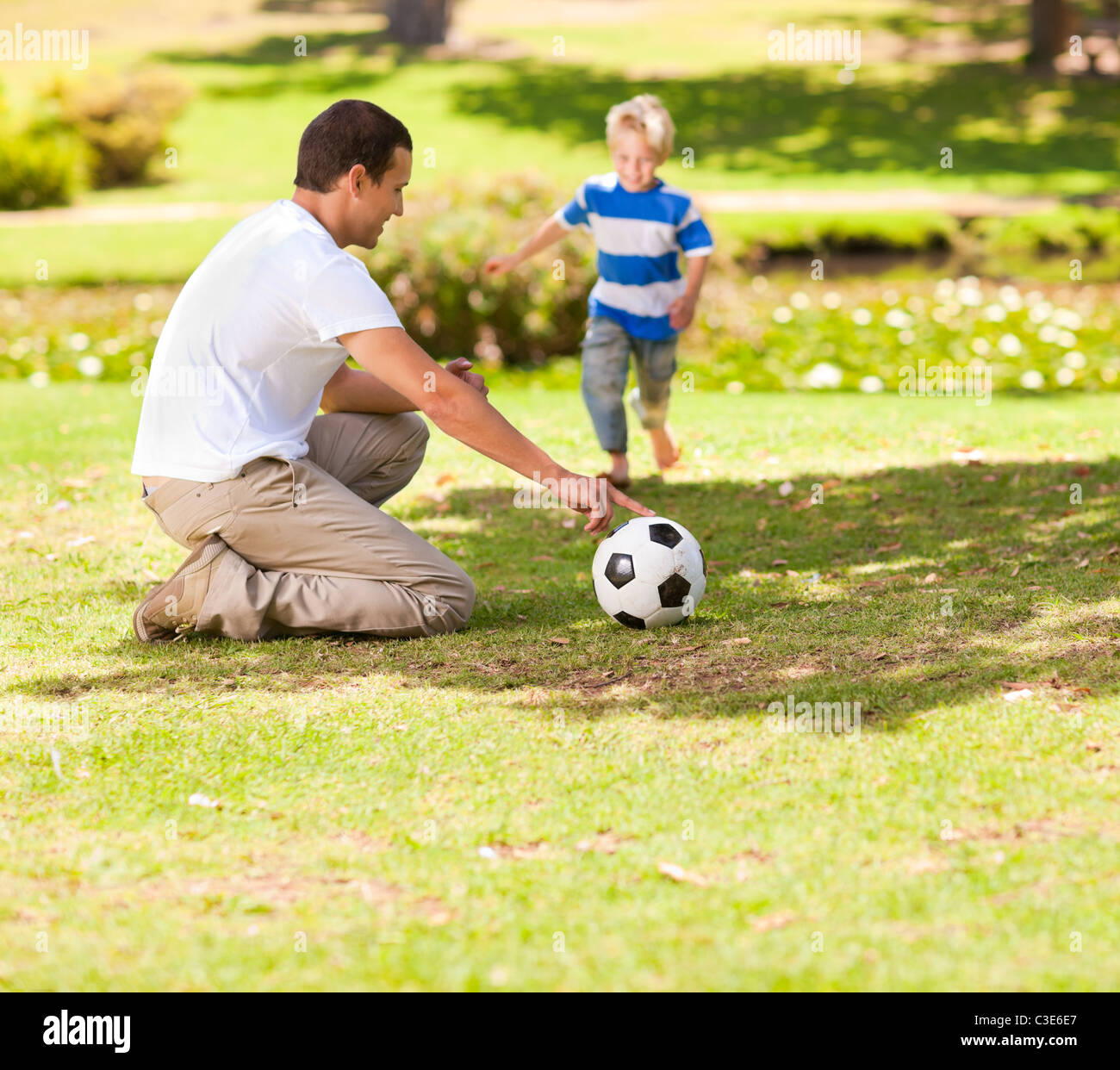 Father playing football with his son during the summer Stock Photo - Alamy