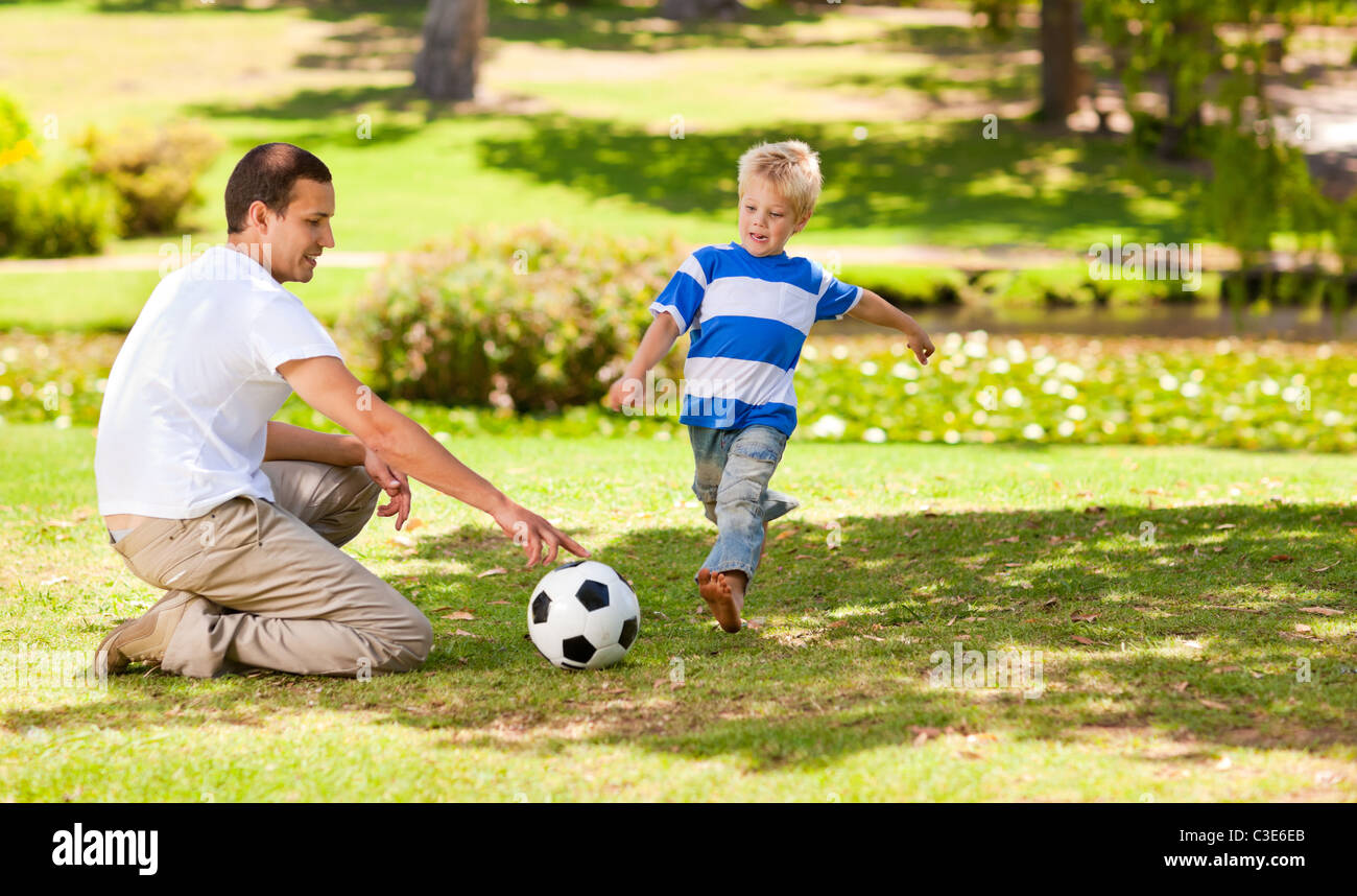 Father playing football with his son in a park Stock Photo - Alamy