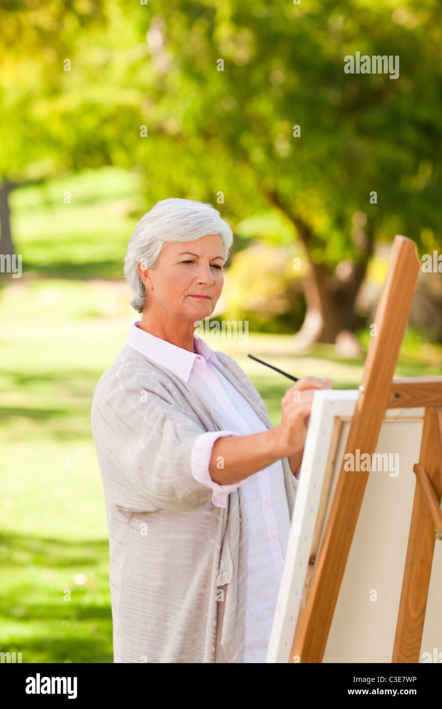 Mature woman painting in the park Stock Photo - Alamy