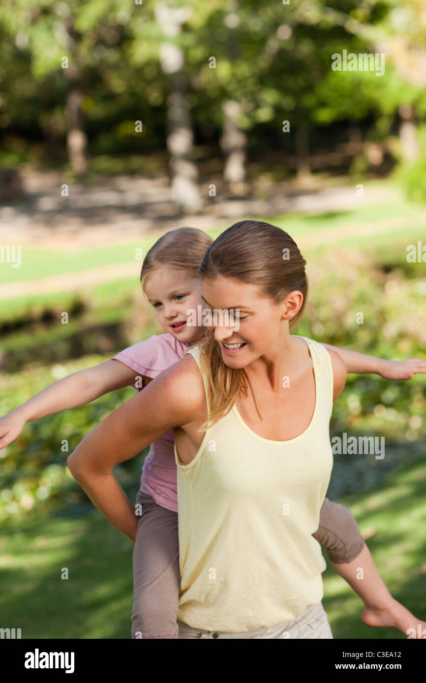 Beautiful mother giving daughter a piggyback Stock Photo - Alamy