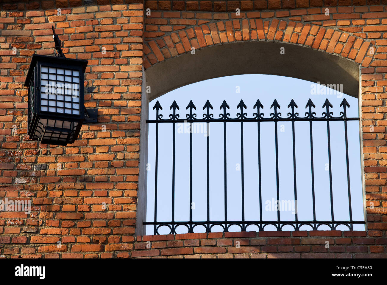 Old spike fence and lantern on a brick wall architectural details Stock ...