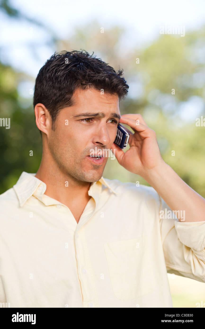 Handsome man phoning in the park Stock Photo - Alamy