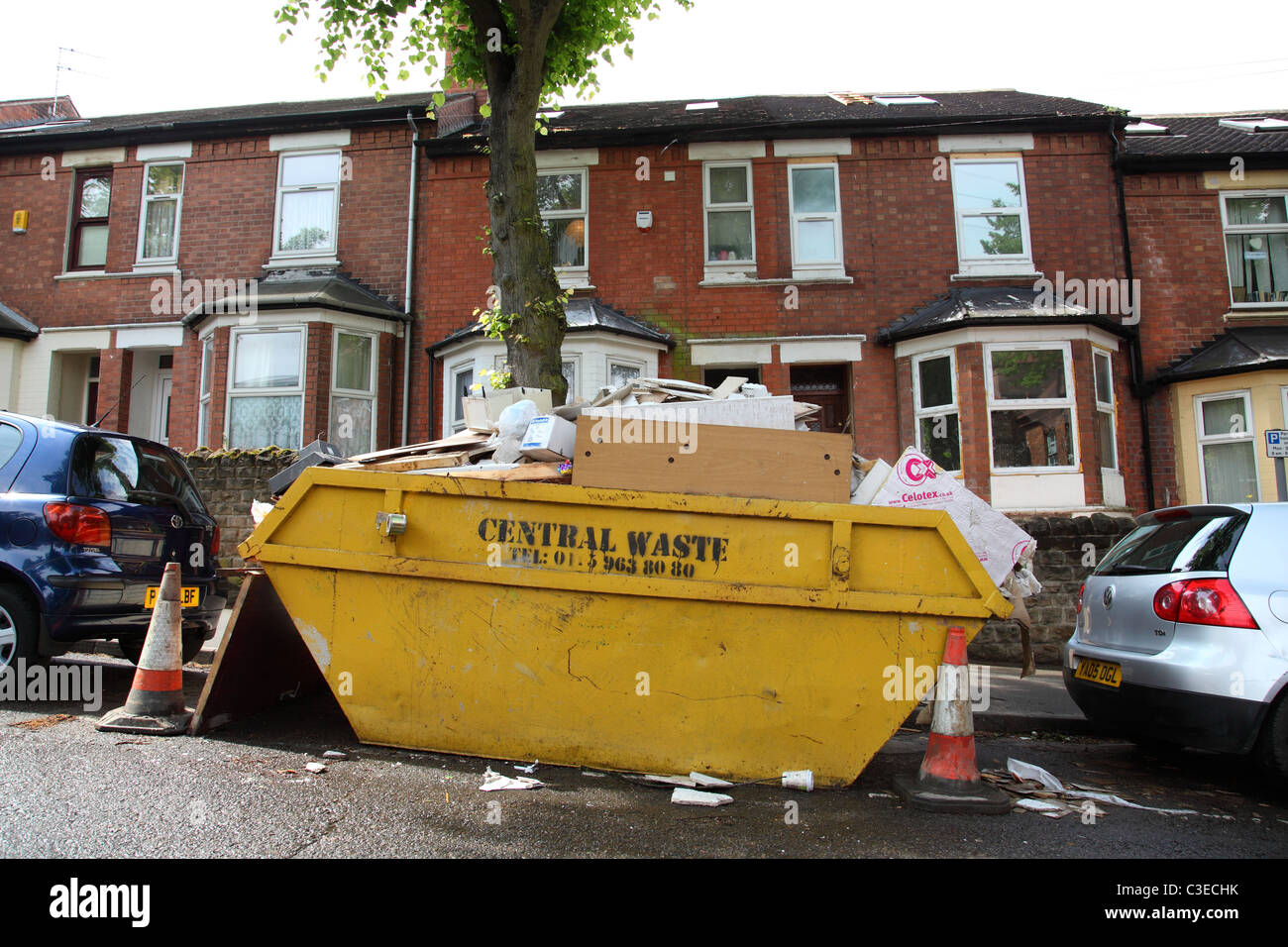A skip outside a house in a U.K. city Stock Photo - Alamy