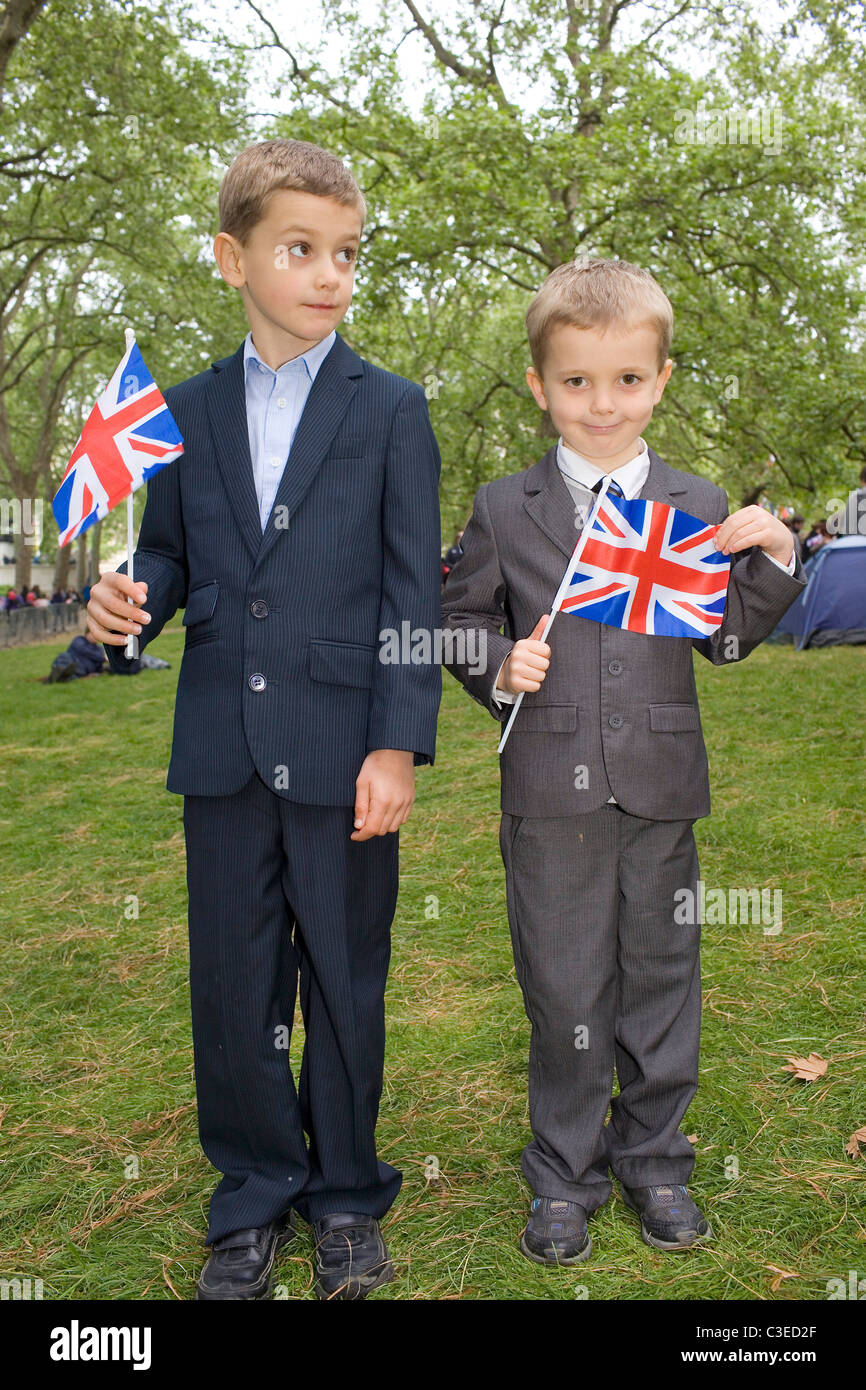 Two brothers wearing suits pose for a photograph with union flags on ...