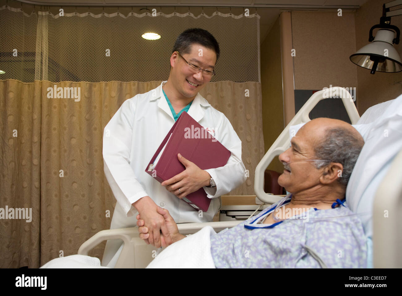 Doctor reassures older patient that he is doing well after surgery ...