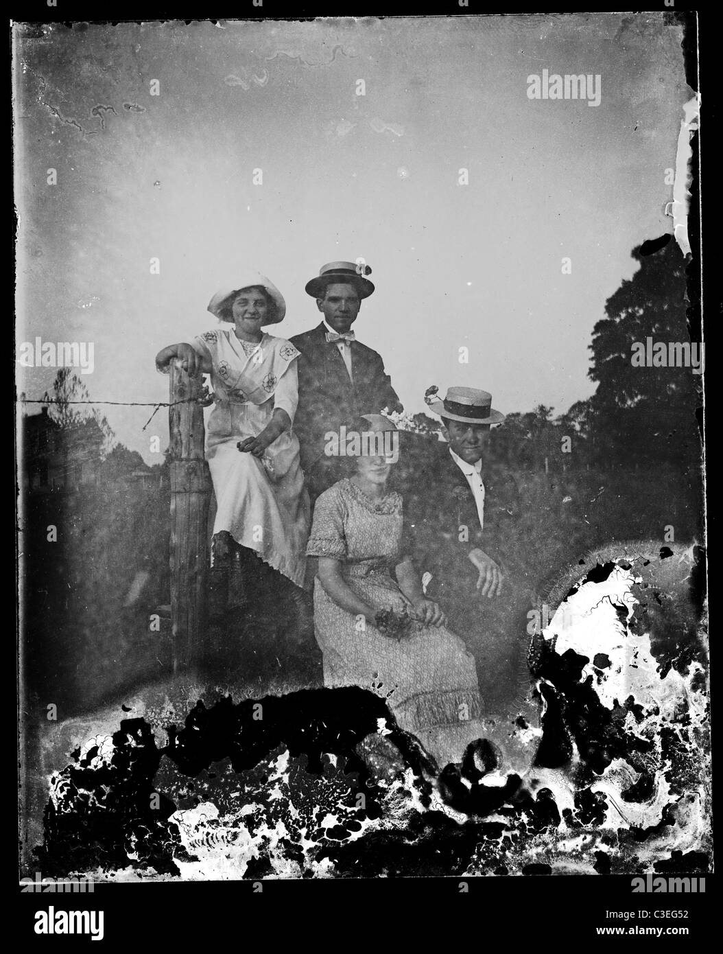 two couples sitting on a fence fashion 1890s Stock Photo - Alamy