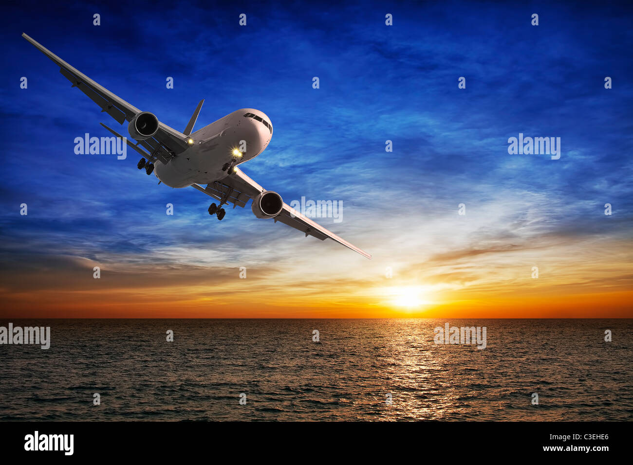 Night flight. Jet aircraft over the sea at dusk Stock Photo - Alamy