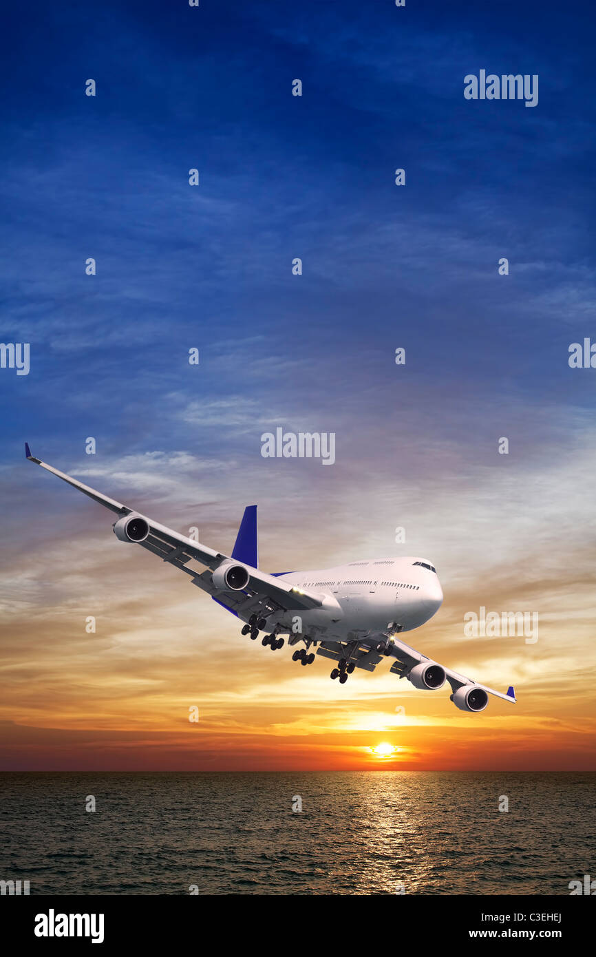 Jet liner over the sea at sunset Stock Photo - Alamy