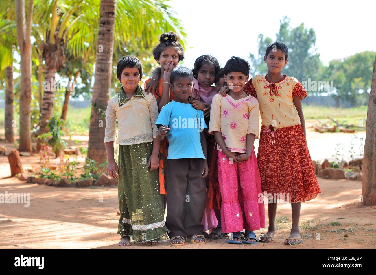 A group of Indian children smile, giggle and pose for this photo under ...