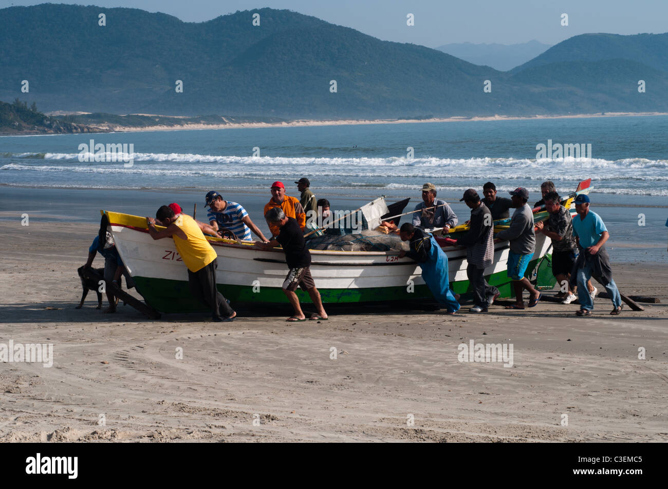 local fisherman pulling their small fishing boat at Garopaba beach ...