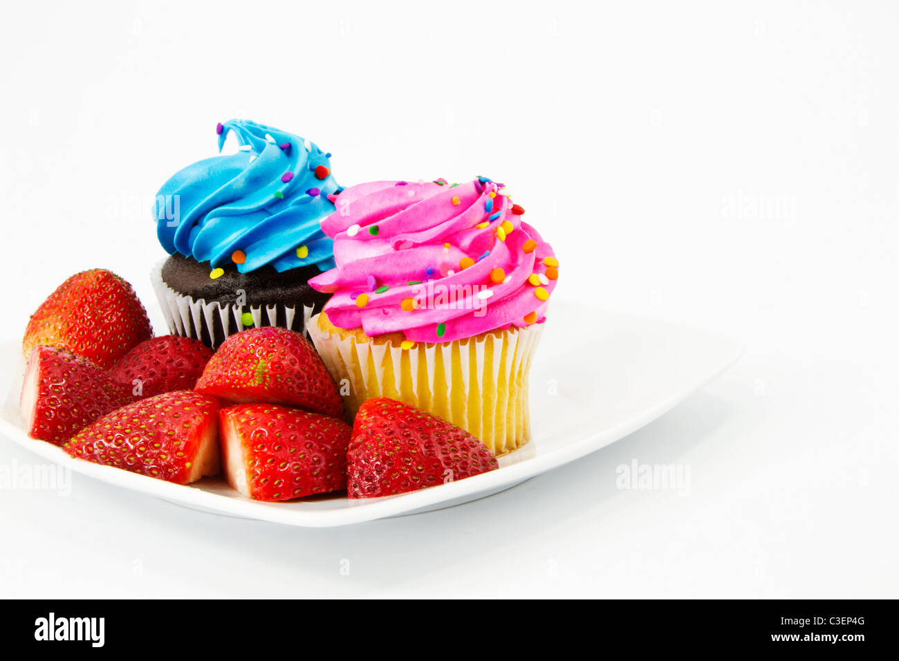 Two cupcakes, one with blue frosting and one with pink frosting, are ...