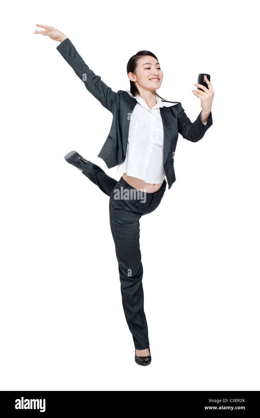 A dancing businesswoman holding a mobile phone Stock Photo - Alamy