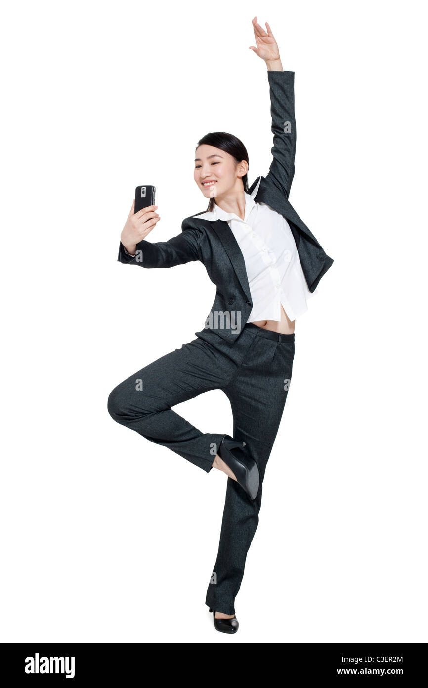 A dancing businesswoman holding a mobile phone Stock Photo - Alamy