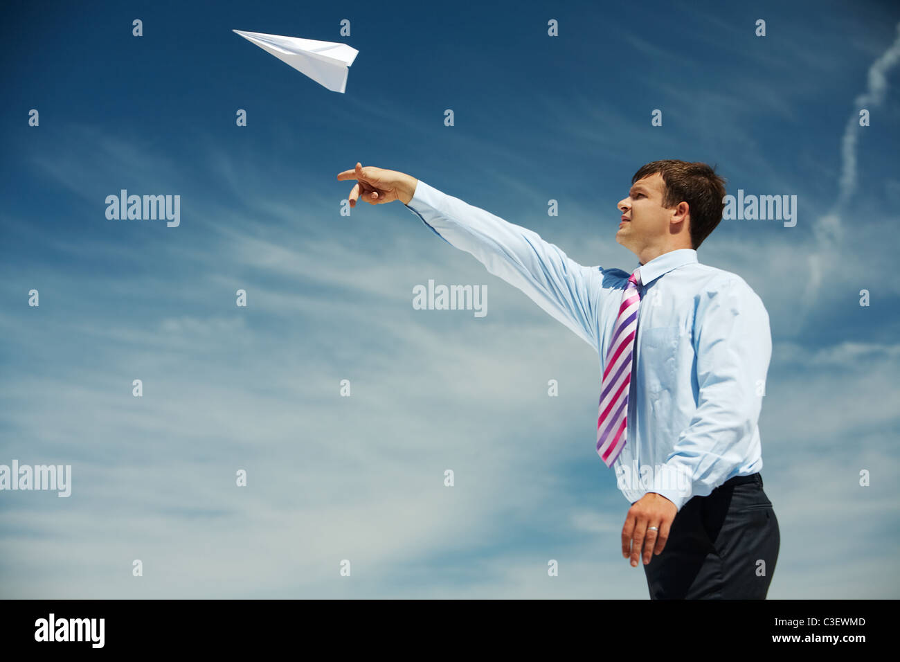 Image of businessman letting paper airplane fly and looking at it on ...