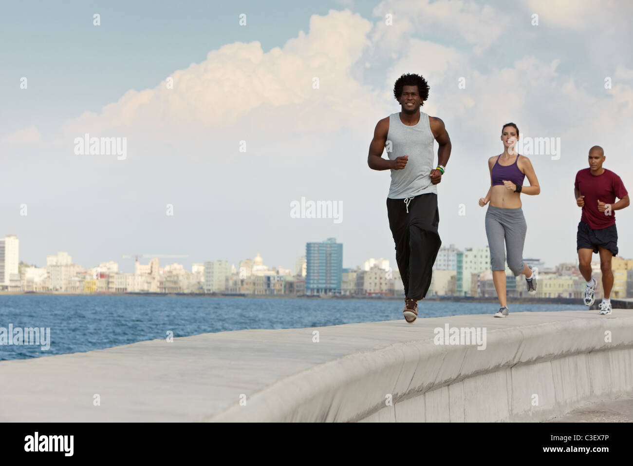 Group of young people running along the Caribbean sea in Havana, Cuba ...