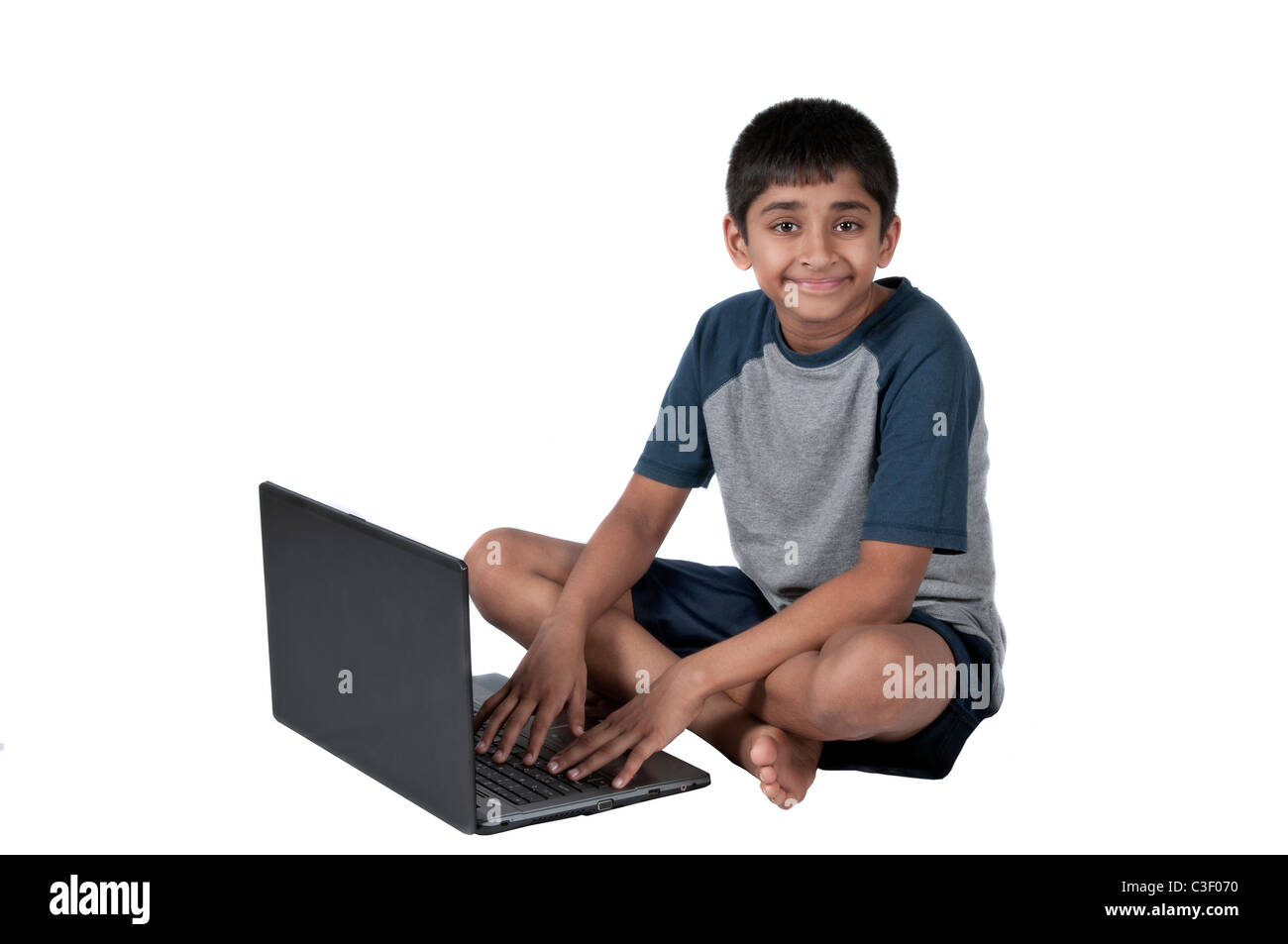 An handsome Indian kid having fun with laptop Stock Photo - Alamy