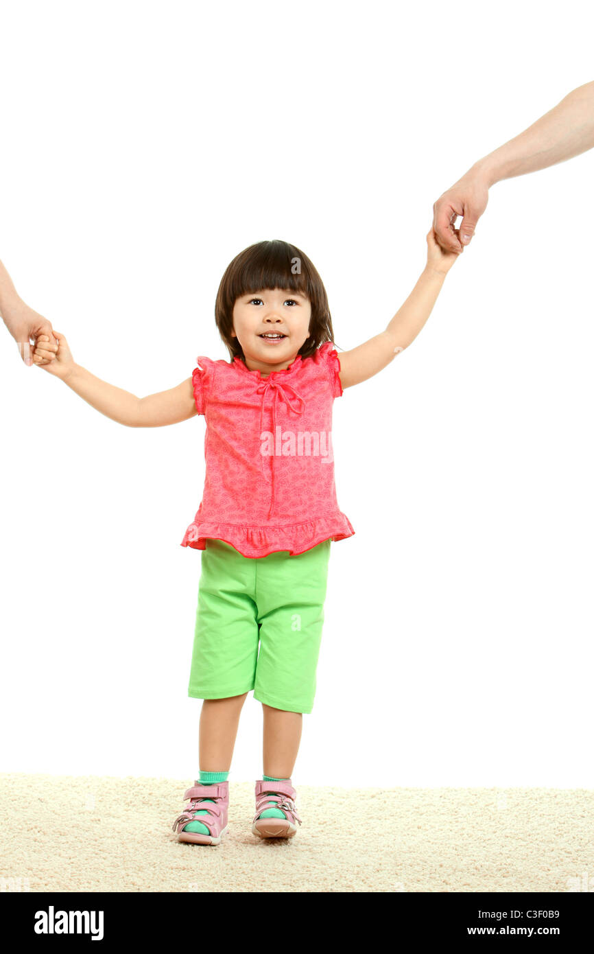 Portrait of cute child being held by her parents while walking Stock ...