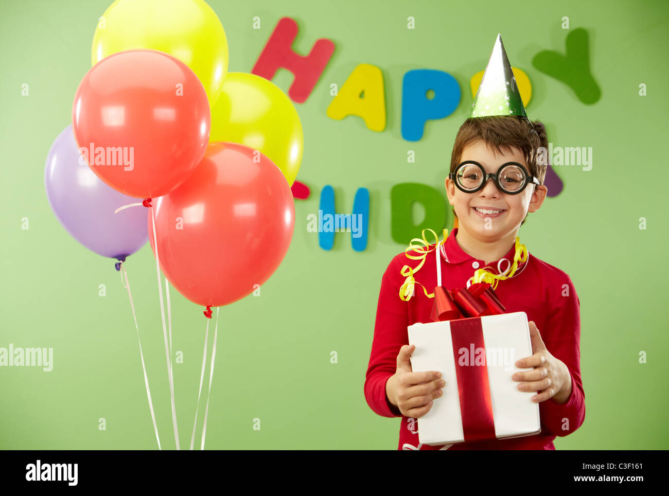 Portrait of happy lad in funny eyeglasses on birthday party with ...
