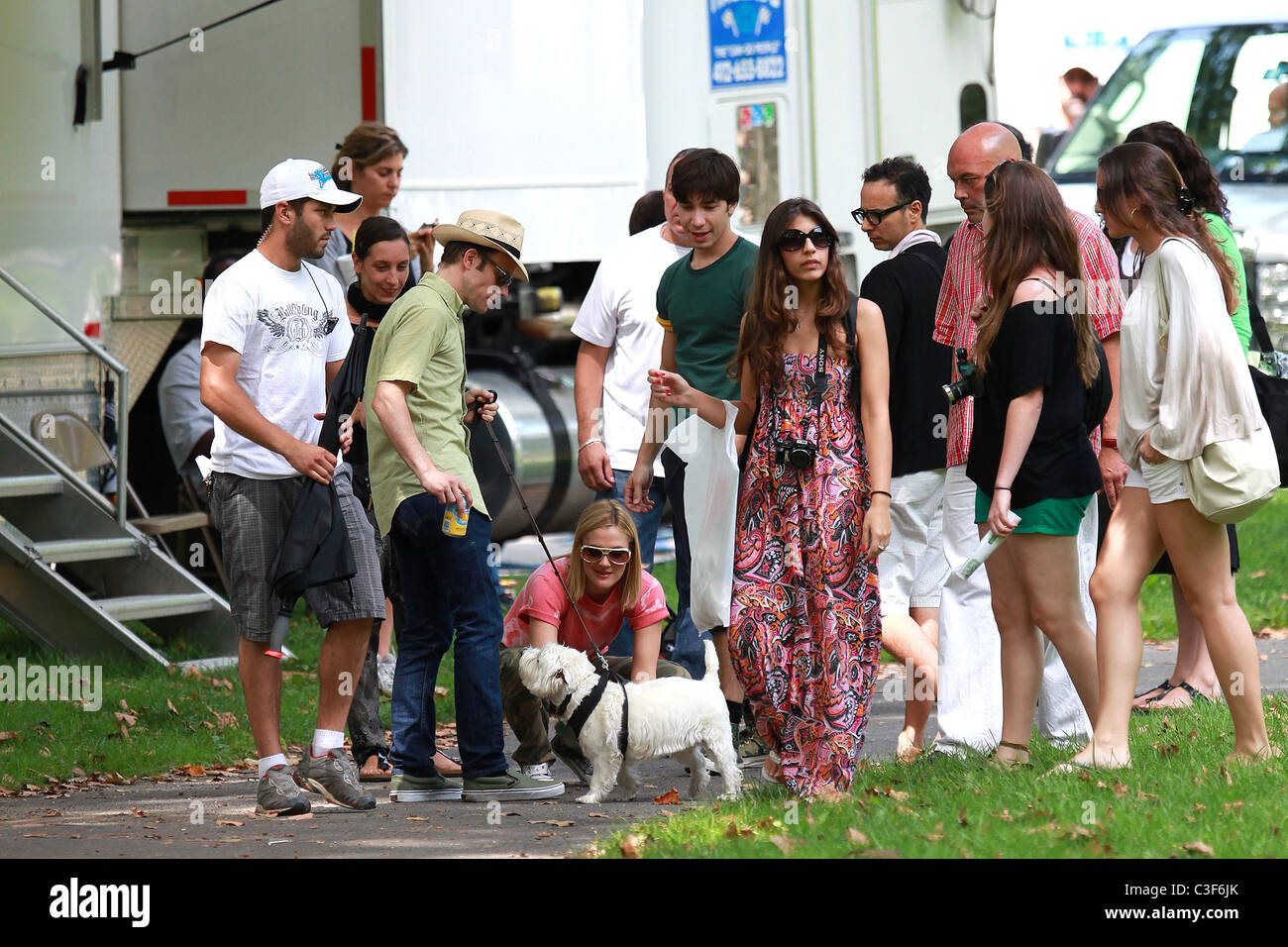 Drew Barrymore and Justin Long play with a dog during a break from ...