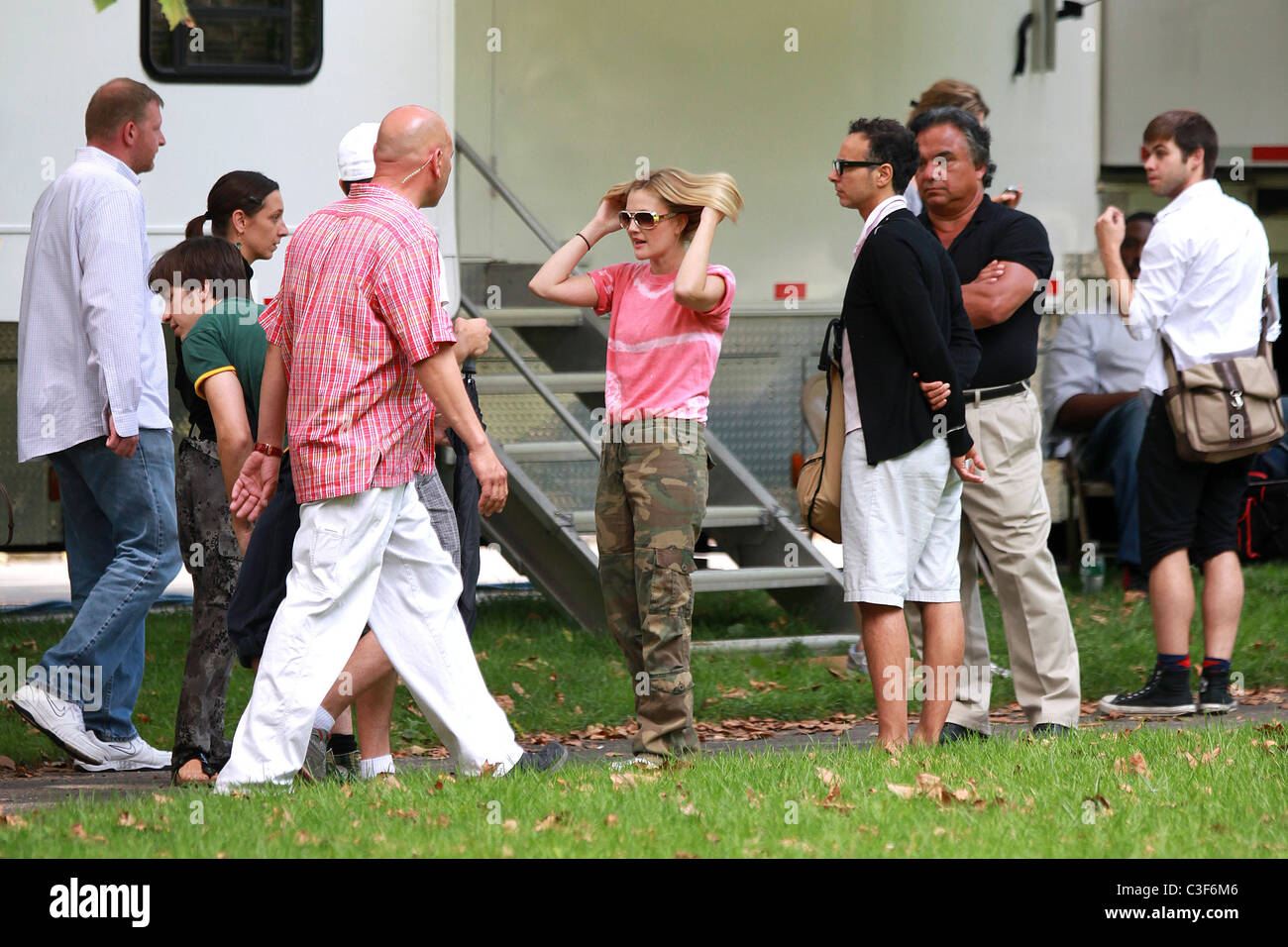 Drew Barrymore and Justin Long play with a dog during a break from ...