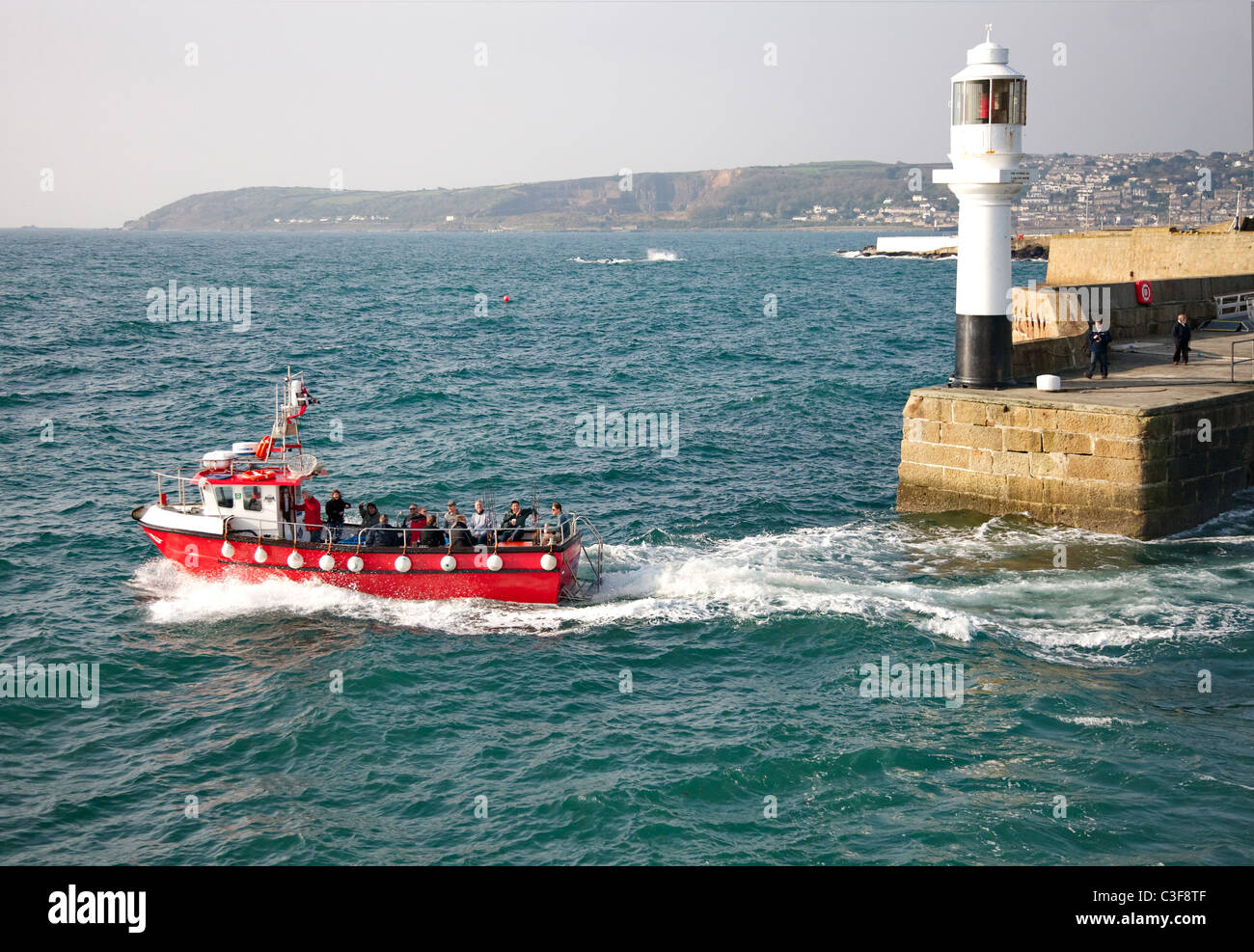 Red ferry boat rounding the harbour light at Penzance in Cornwall Stock ...