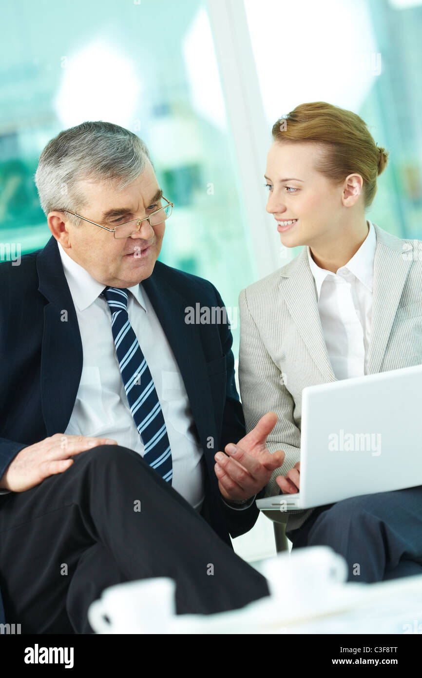 Portrait of boss and employee working with laptop in office Stock Photo ...