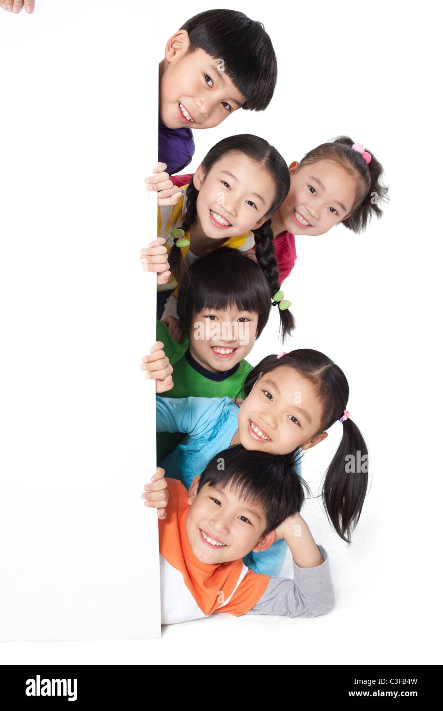 A group of children hiding their bodies behind a wall Stock Photo - Alamy