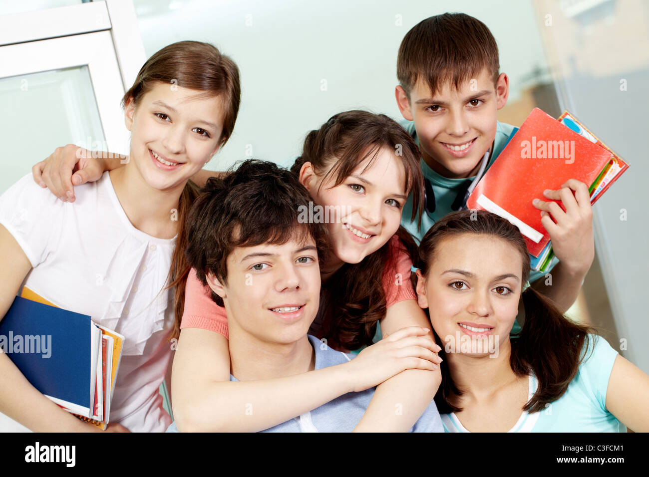 Portrait of five students embracing looking at camera and smiling Stock ...