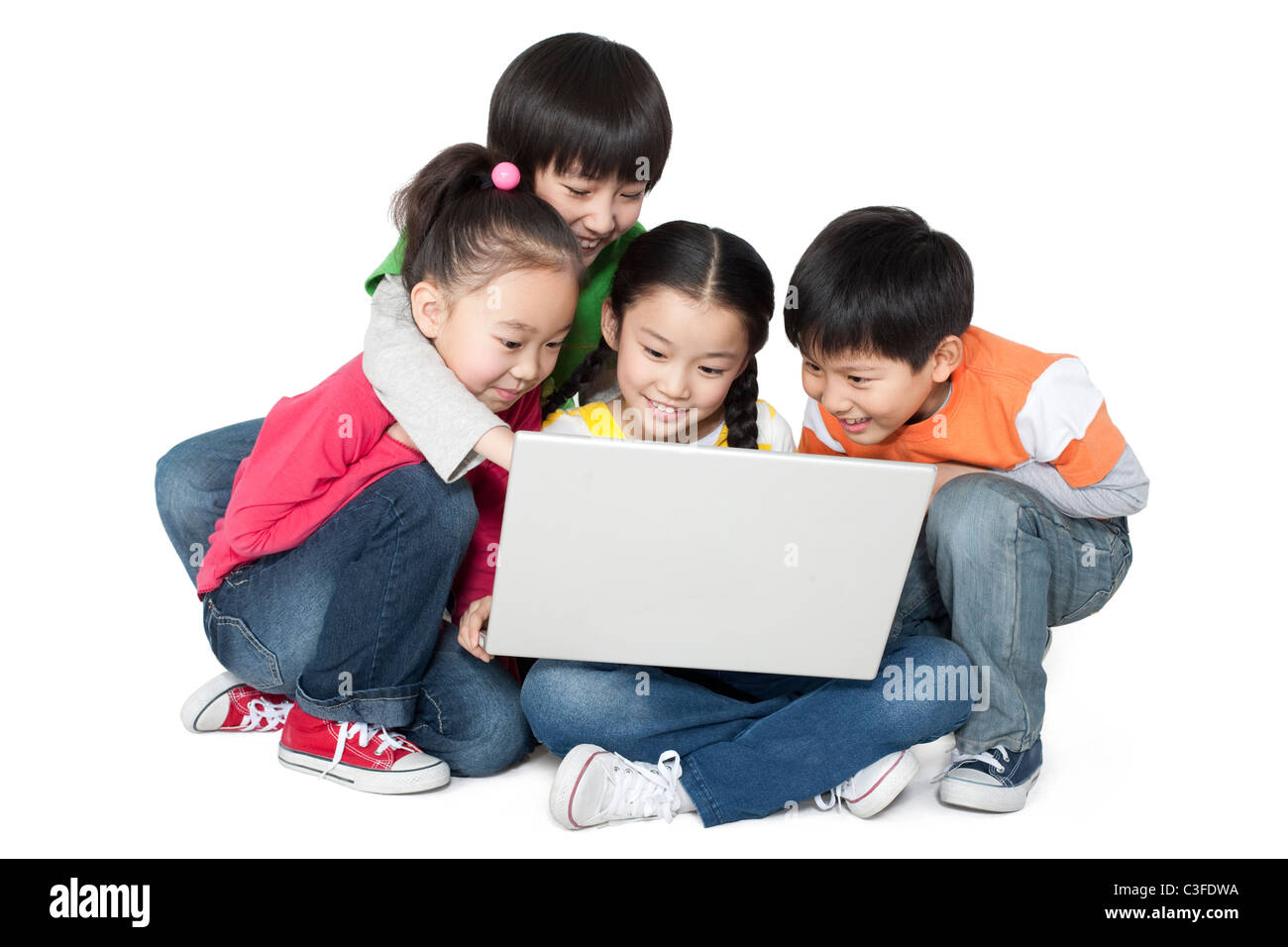 A group of children using a laptop together Stock Photo - Alamy