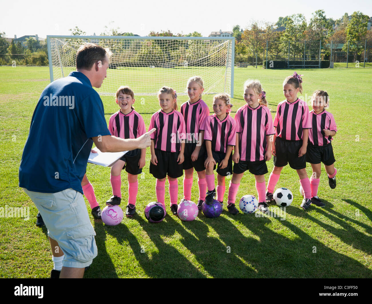 Coach motivating girl soccer players Stock Photo - Alamy