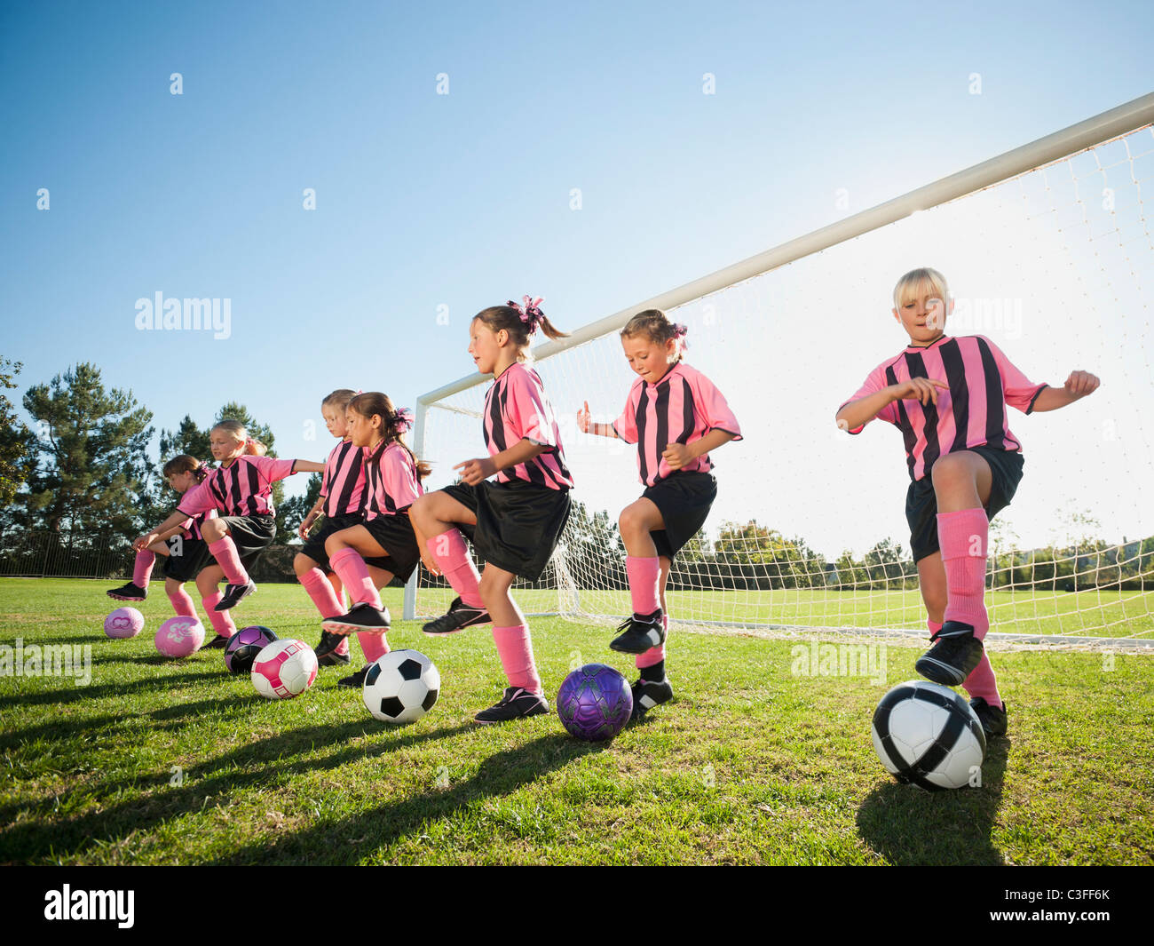 Girl soccer players practicing near net Stock Photo - Alamy