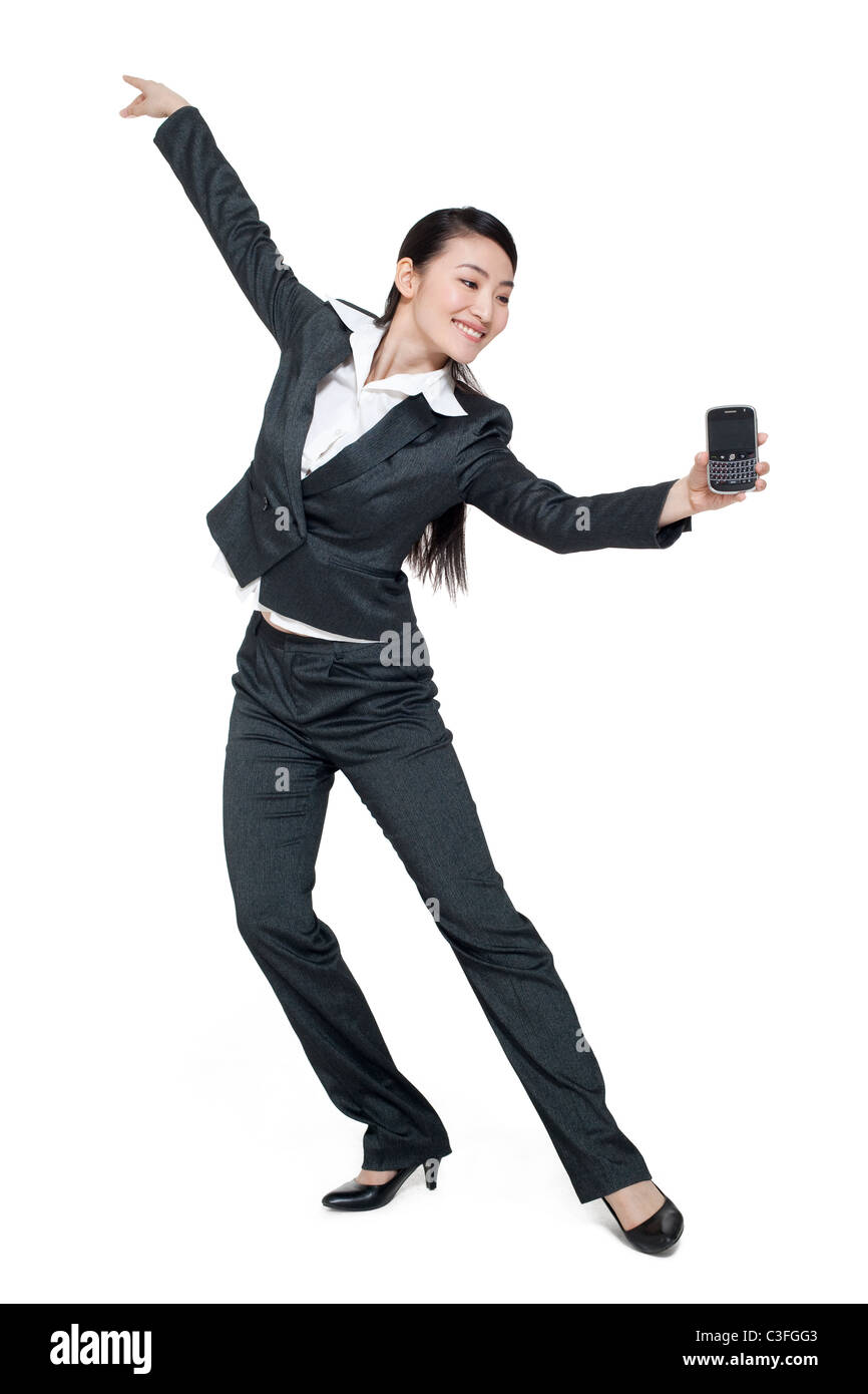 A dancing businesswoman holding a mobile phone Stock Photo - Alamy