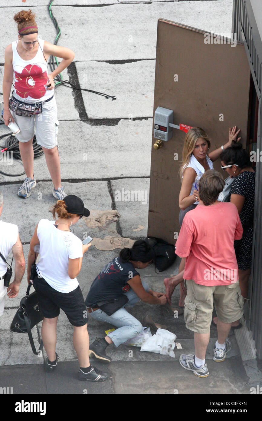 Jennifer Aniston has an assistant attend to her high heels while on the ...
