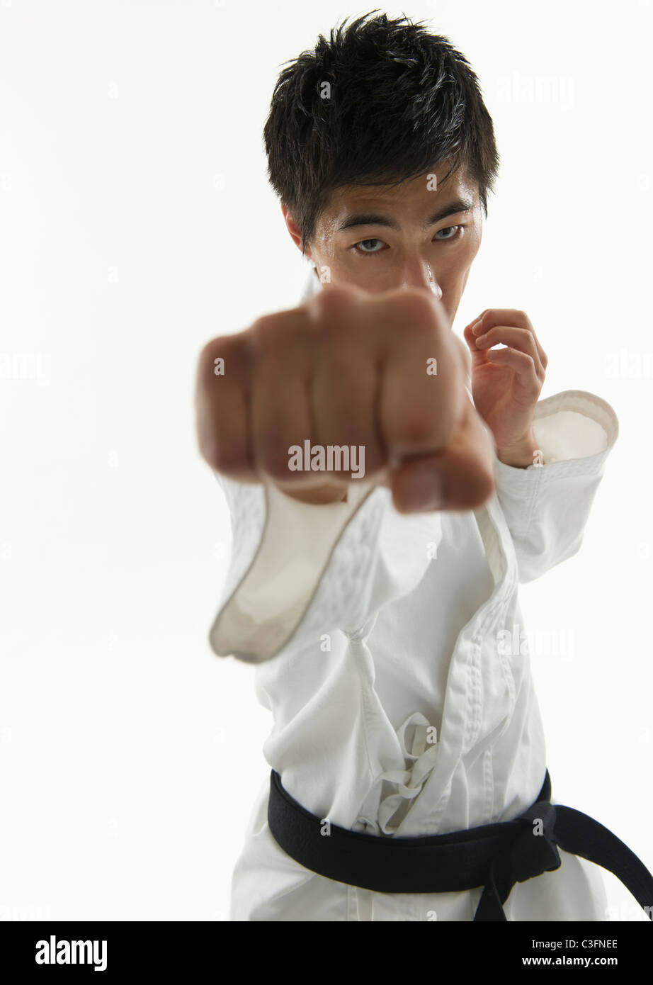 Asian male karate black belt punching Stock Photo - Alamy