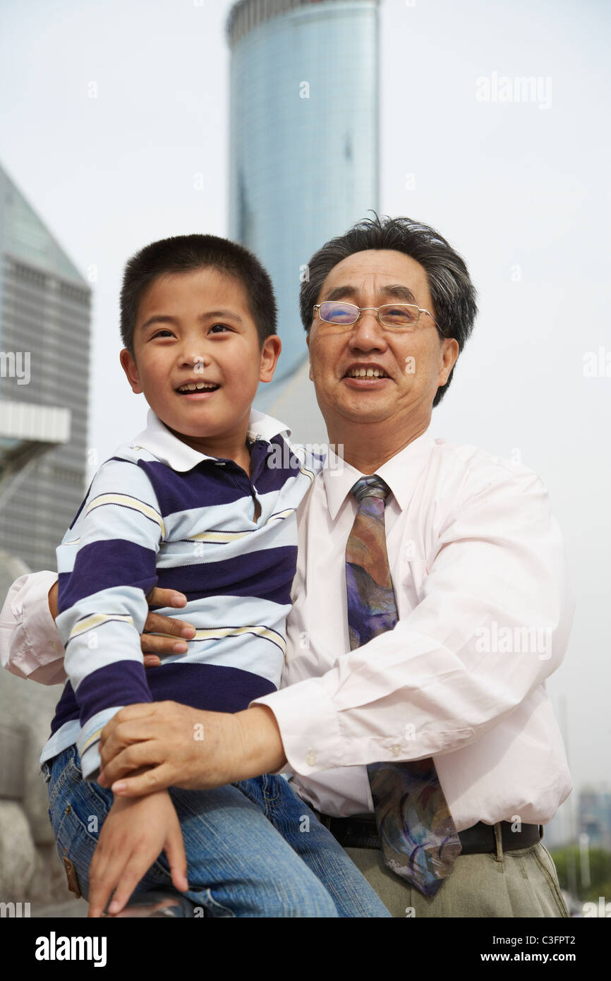 Chinese grandfather and grandson sitting together outdoors Stock Photo ...