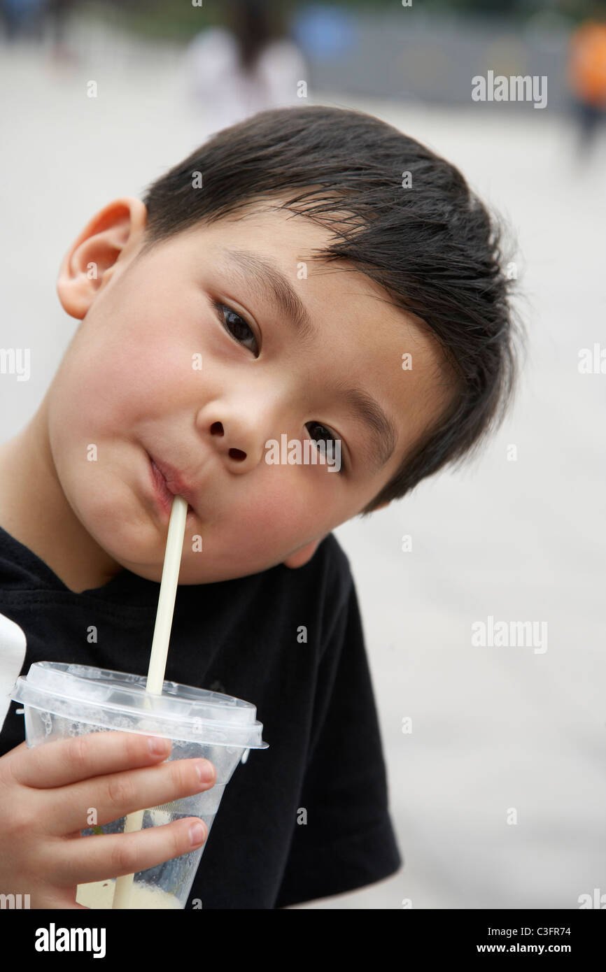 Chinese boy sipping drink Stock Photo - Alamy
