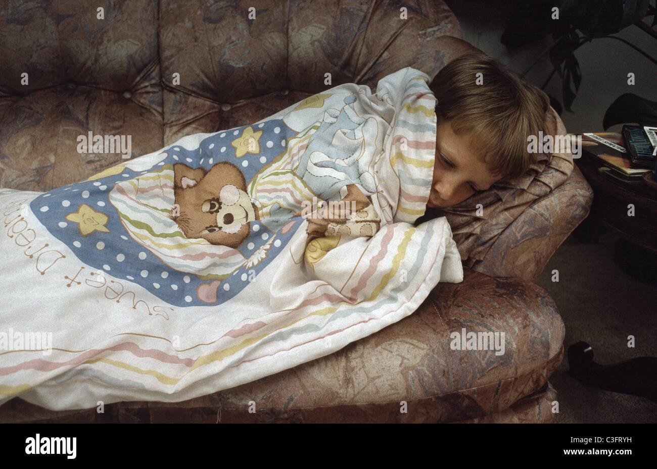 young sick boy lying on the coach with a blanket Stock Photo - Alamy