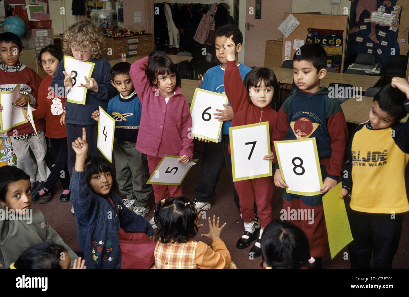 year one students in primary school playing with numbered cards Stock ...
