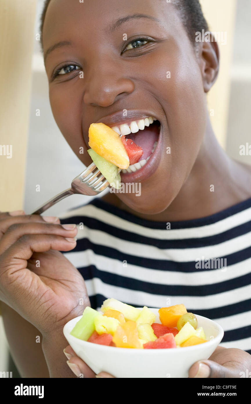 African American woman eating fruit salad Stock Photo - Alamy