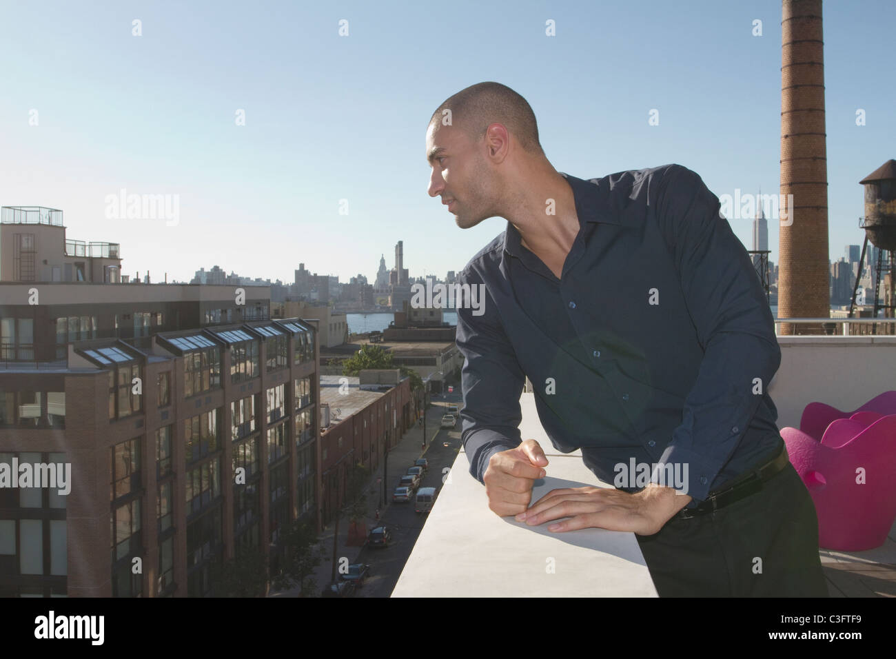 Mixed race man standing on urban balcony Stock Photo - Alamy