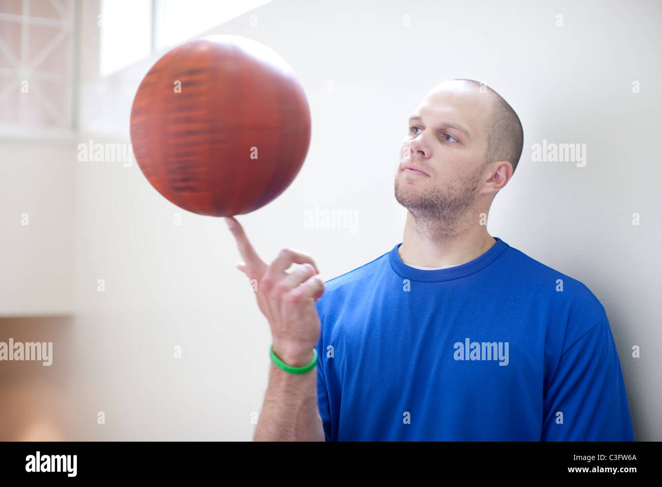 Caucasian man spinning basketball on finger Stock Photo - Alamy