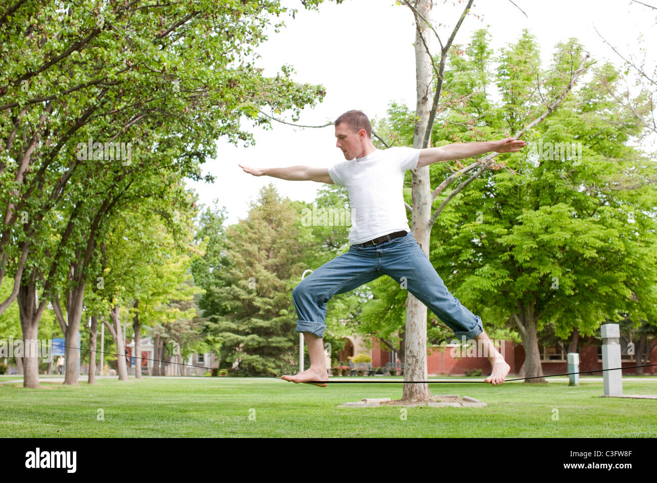 Caucasian man balancing on rope in park Stock Photo - Alamy