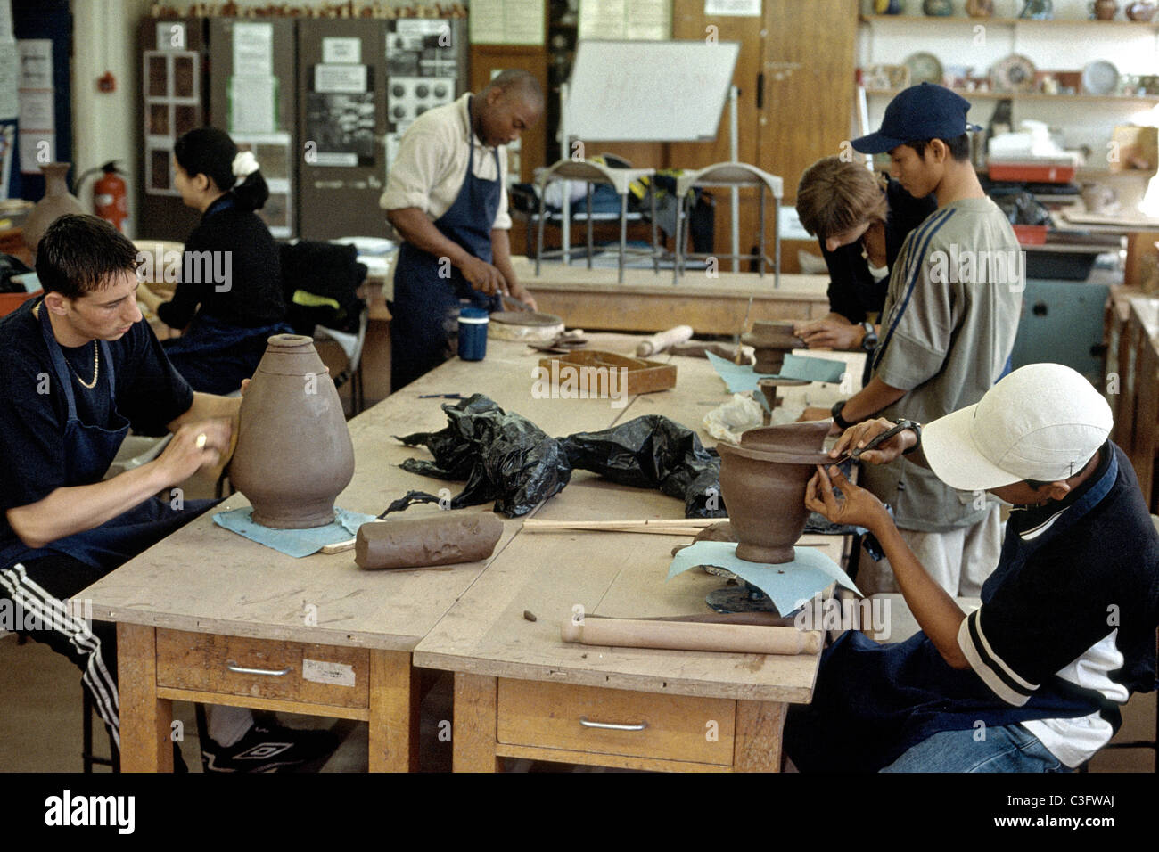 secondary school classroom scene showing students working with clay ...